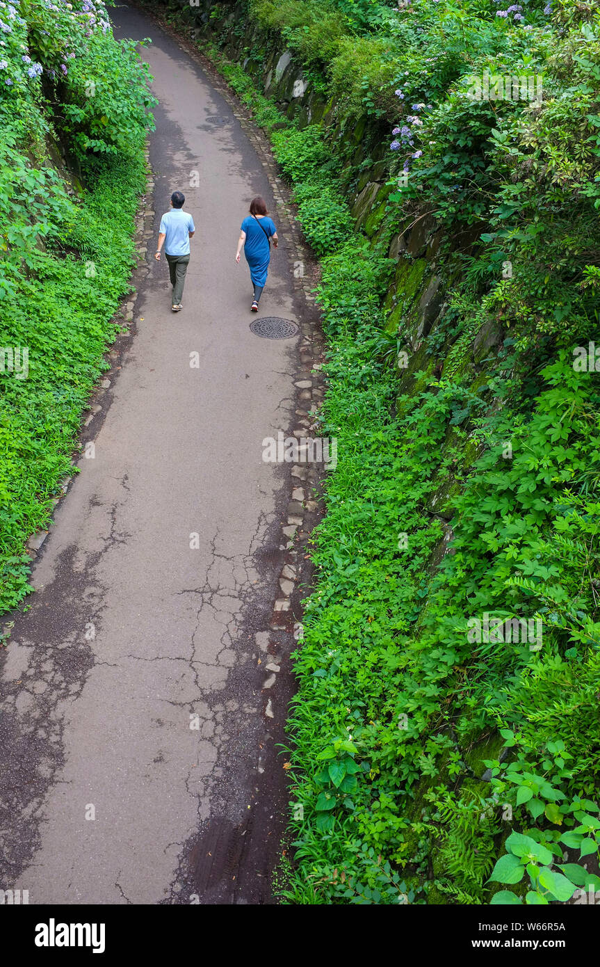A middle aged couple walking along a a small road Stock Photo - Alamy