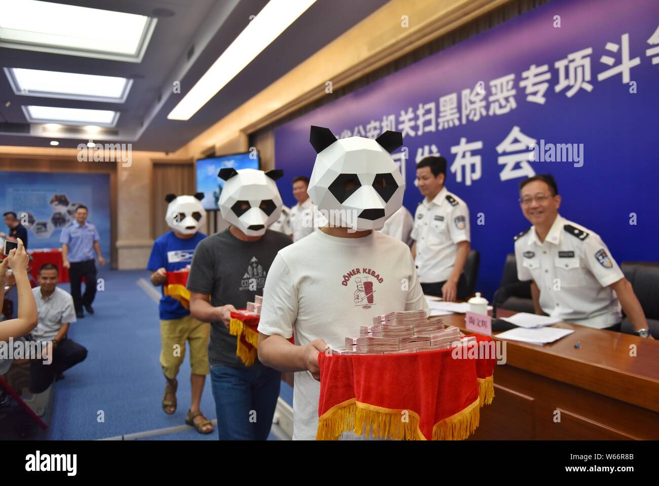 Three men with giant panda masks receive cash rewards for reporting ...