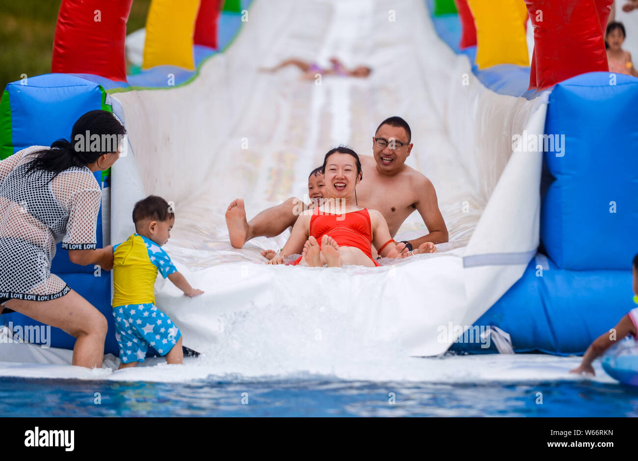 Tourists play on Asia's longest water slide at Jingzhihu Resort in ...