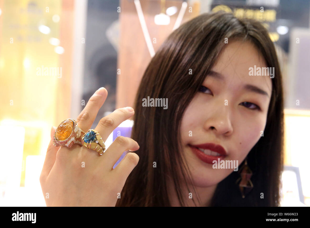 A visitor shows gemstone rings on display during the Summer Jewelry ...