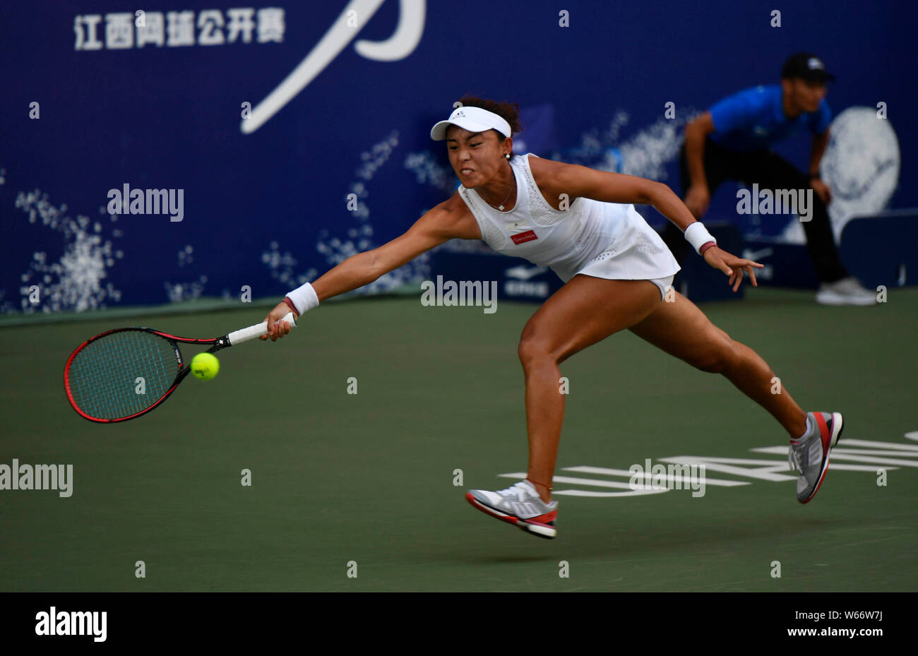 Wang Qiang of China returns a shot to Sabina Sharipova of Uzbekistan in ...
