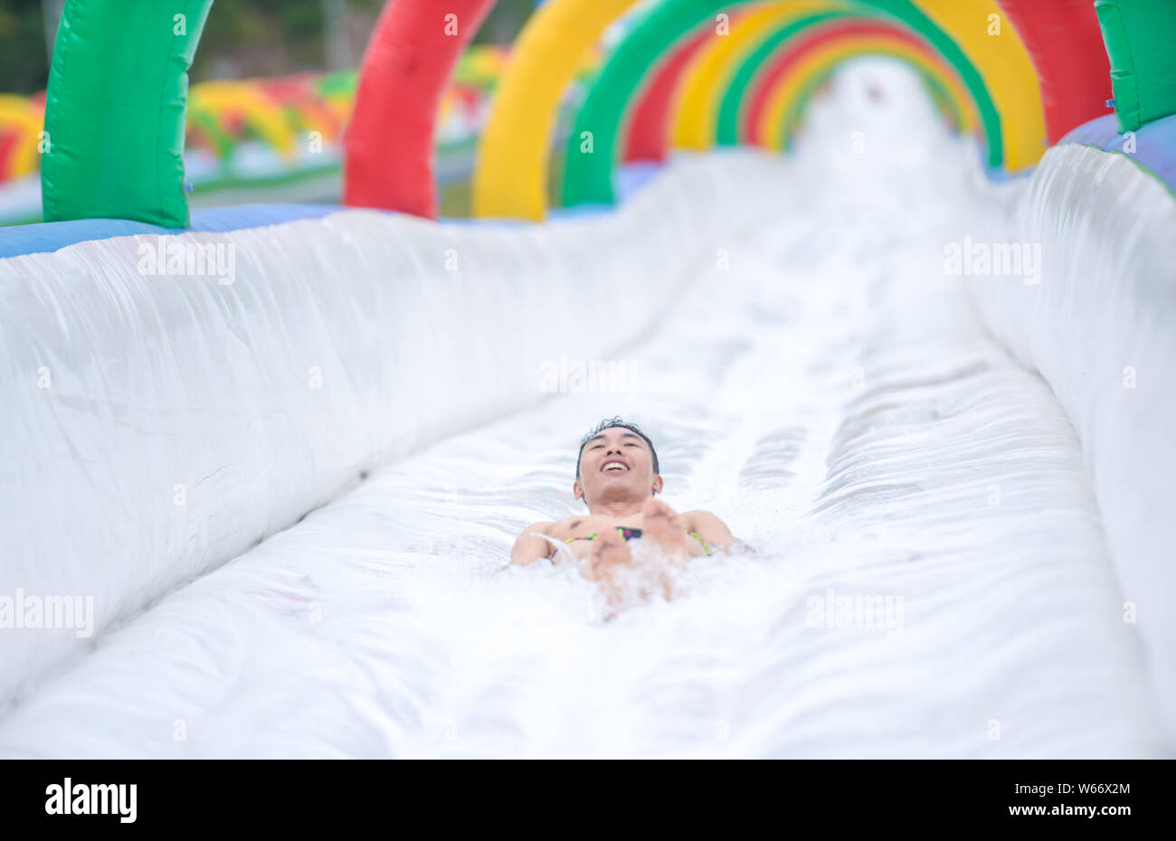 A tourist plays on Asia's longest water slide at Jingzhihu Resort in ...