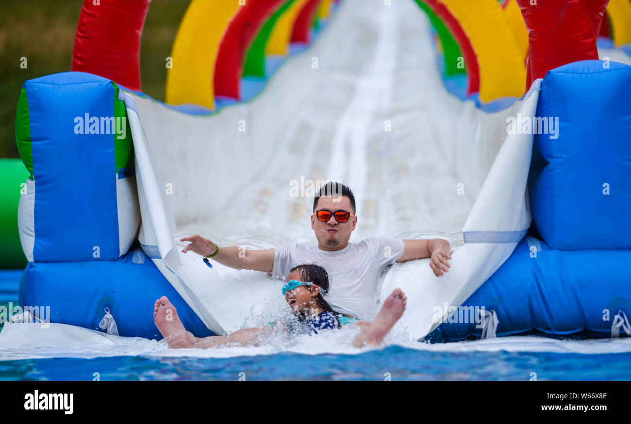 Tourists play on Asia's longest water slide at Jingzhihu Resort in ...
