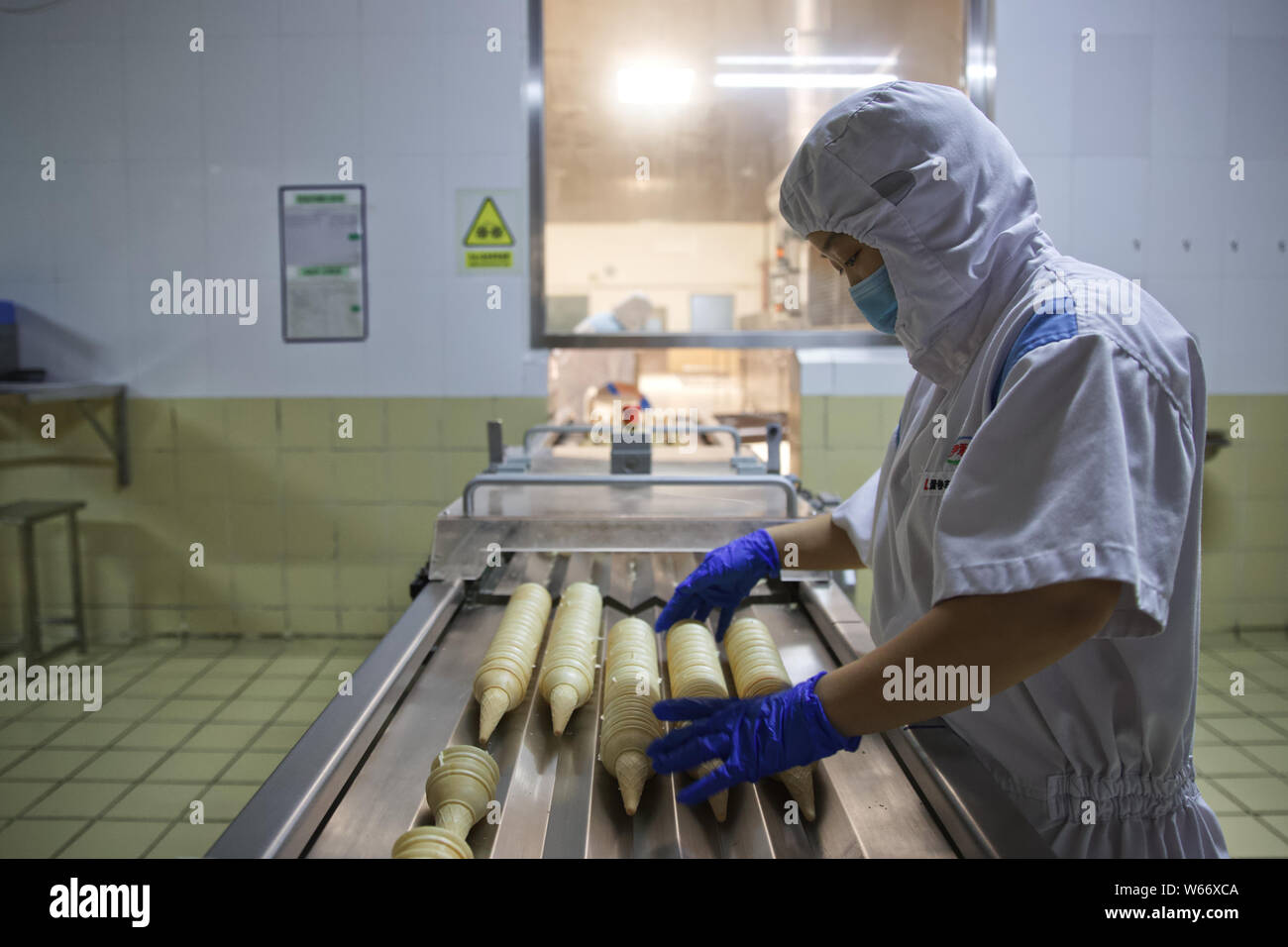 A worker produces Yili torch ice creams on the assembly line at a ...