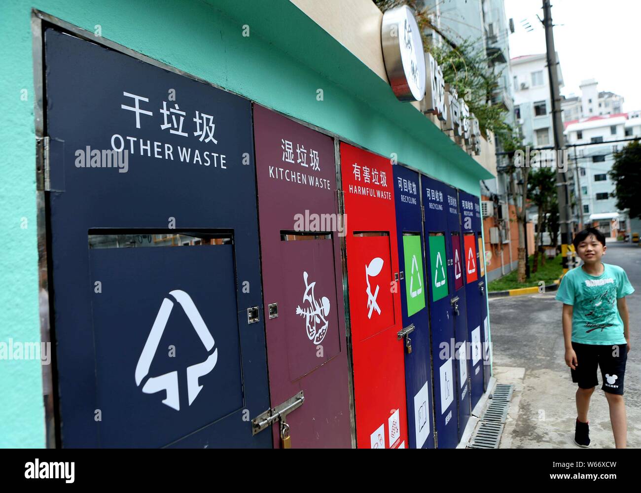 A local resident walks past a smart bin deployed to meet the new ...