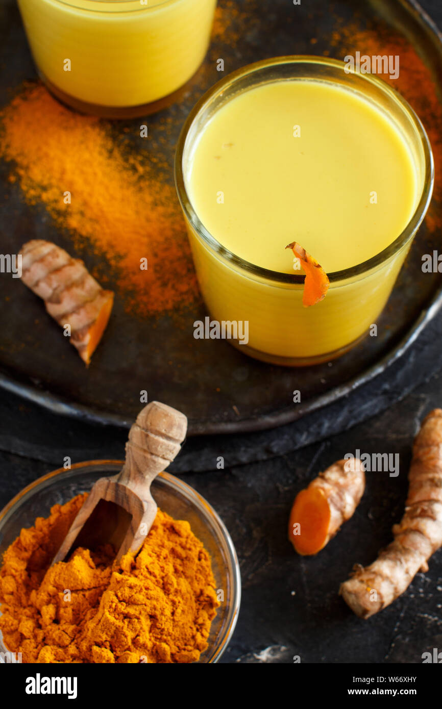 Golden milk with turmeric powder in a glass close up Stock Photo - Alamy
