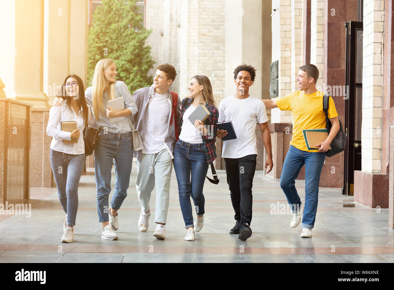 Happy students walking together in campus, having break Stock Photo - Alamy