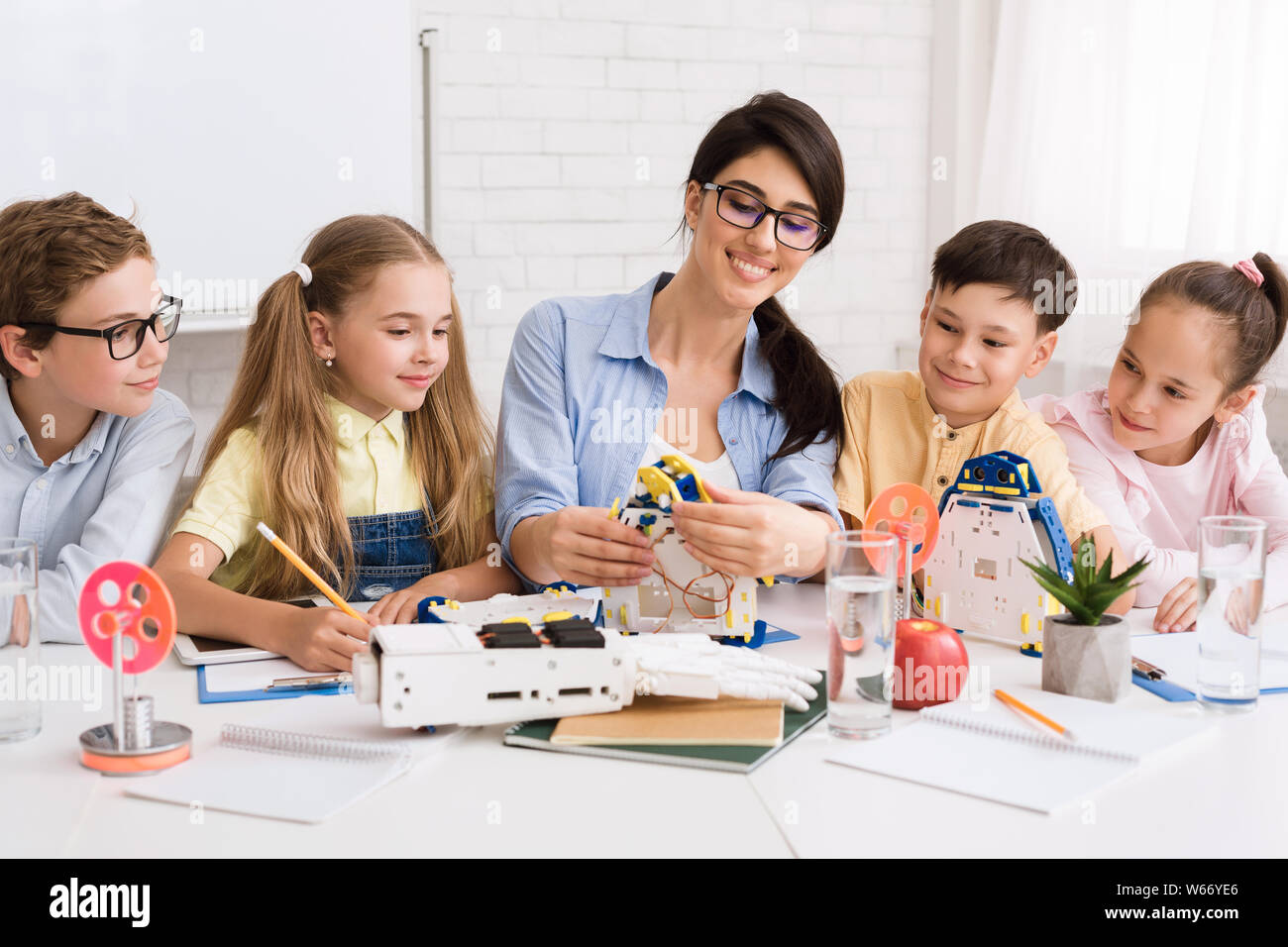 Teacher helping her students with diy robots Stock Photo - Alamy