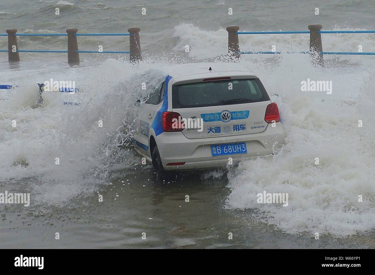 A car is hit by huge waves from a tidal bore caused by Typhoon Ampil ...
