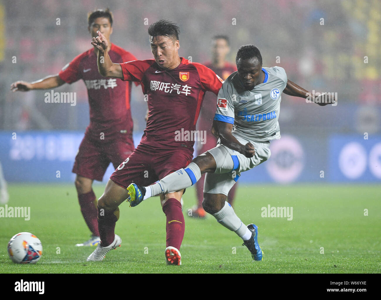 A player of FC Schalke 04, right, challenges Zhao Yuhao of Hebei China ...