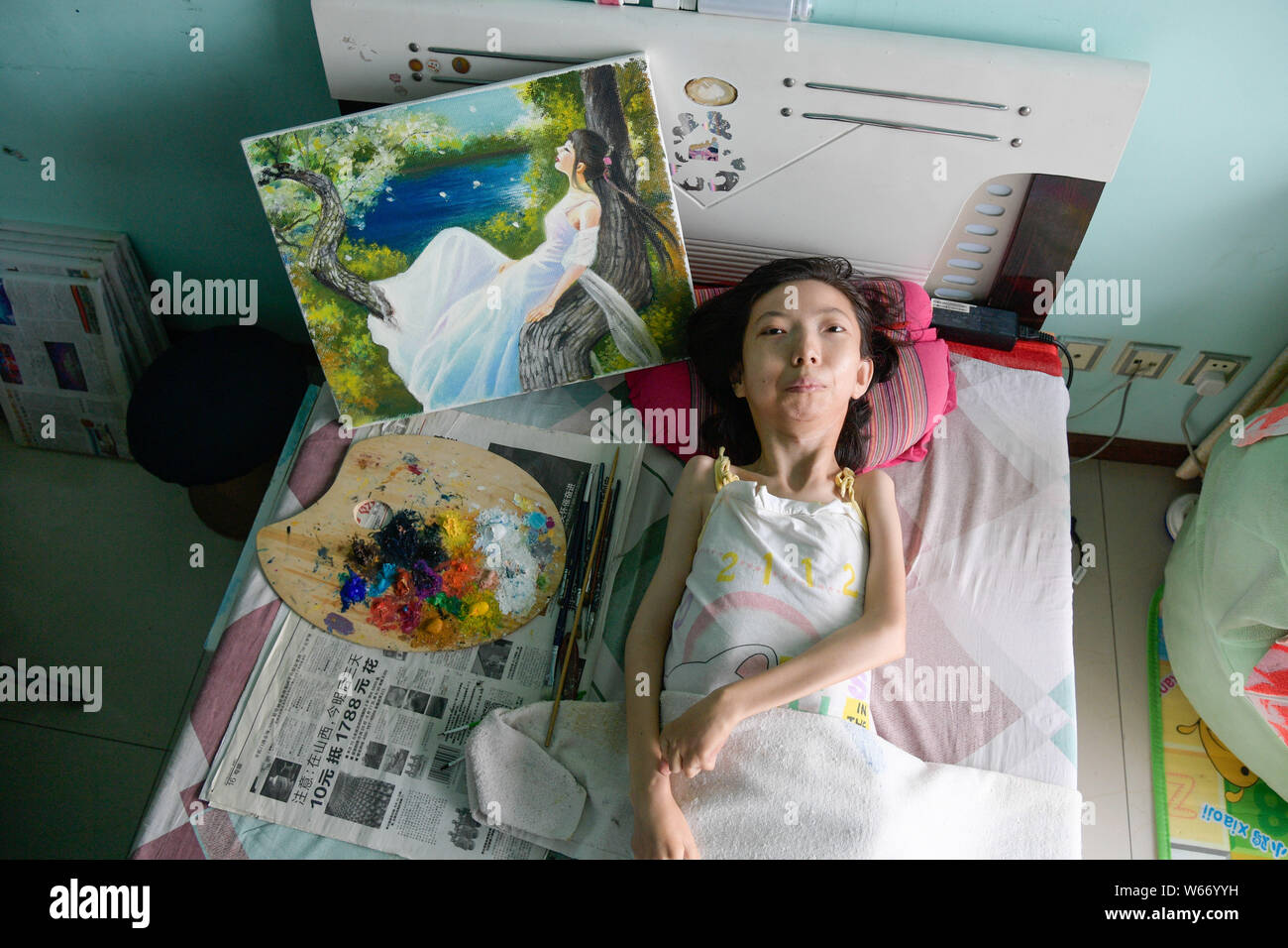 40-year-old Chinese woman Zhang Junli, who has been paralyzed since she was eight, poses with an ...
