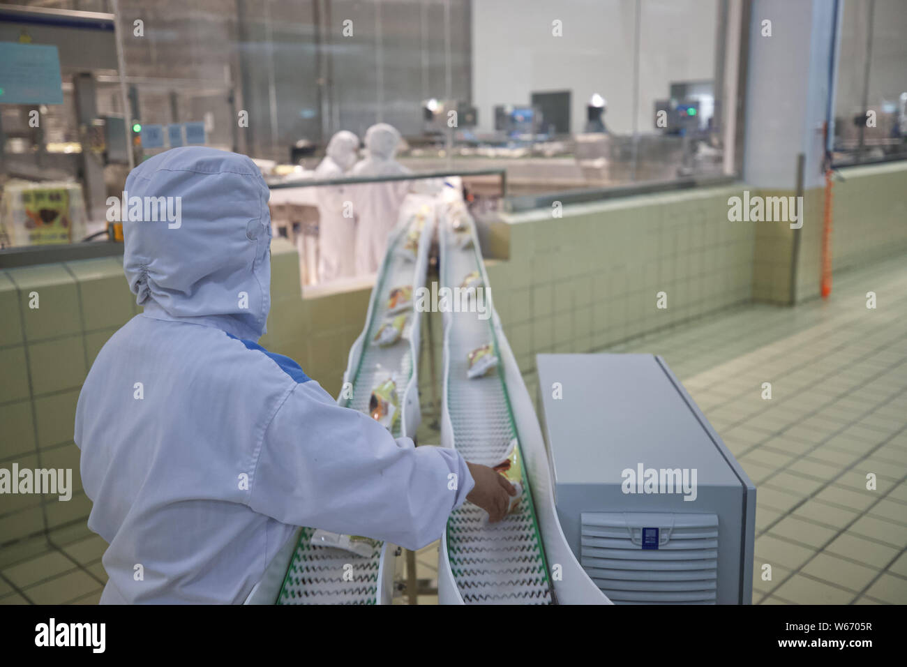 A worker produces Yili torch ice creams on the assembly line at a ...