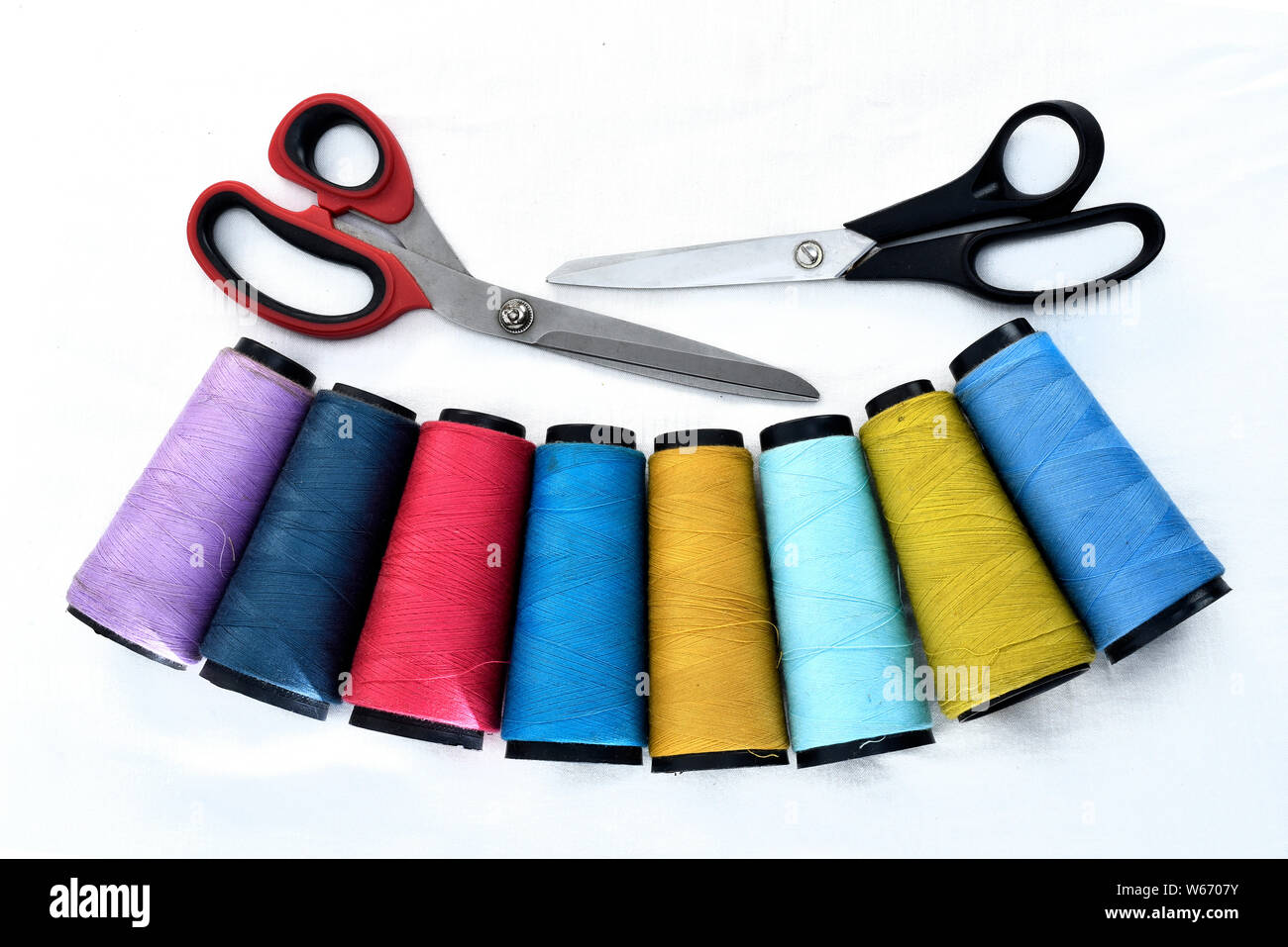 Colorful sewing thread reels on white background with scissors Stock ...