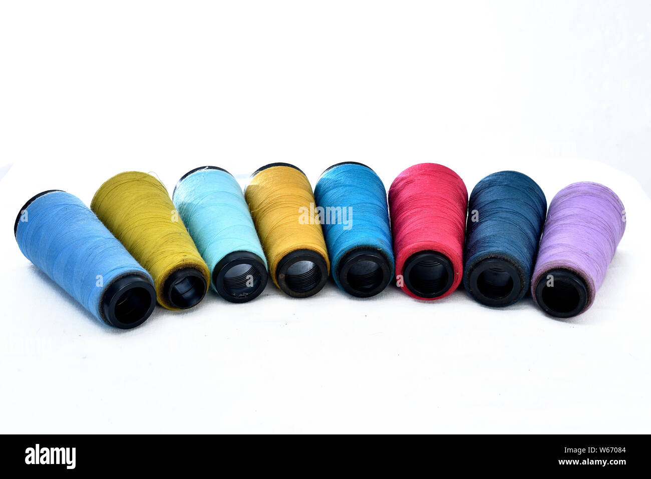 Colorful sewing thread reels on white background Stock Photo - Alamy