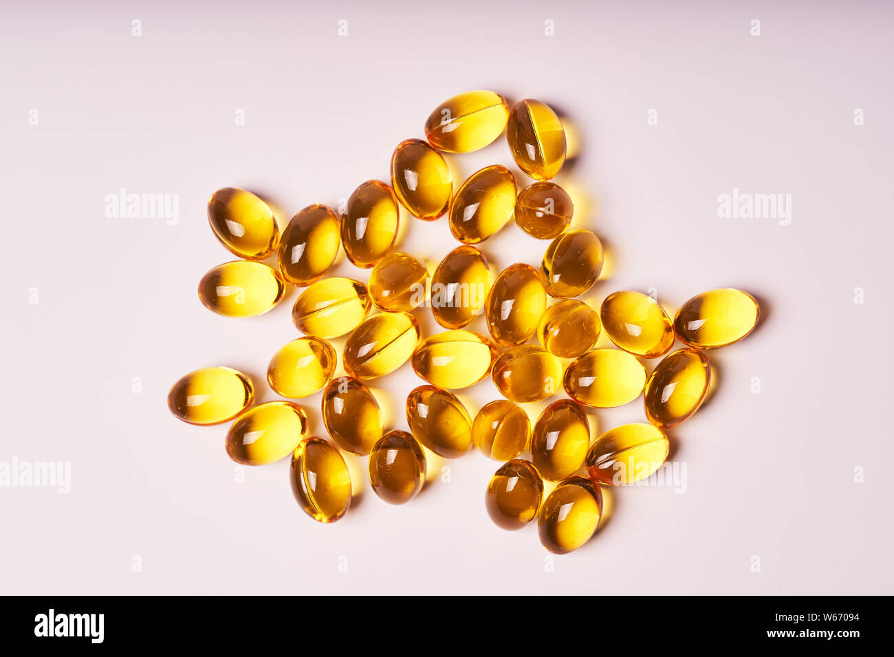 Yellow, transparent vitamin D capsules on white background Stock Photo ...