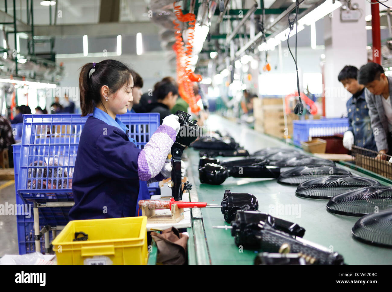 --FILE--Chinese workers produce components and parts of electric fans ...