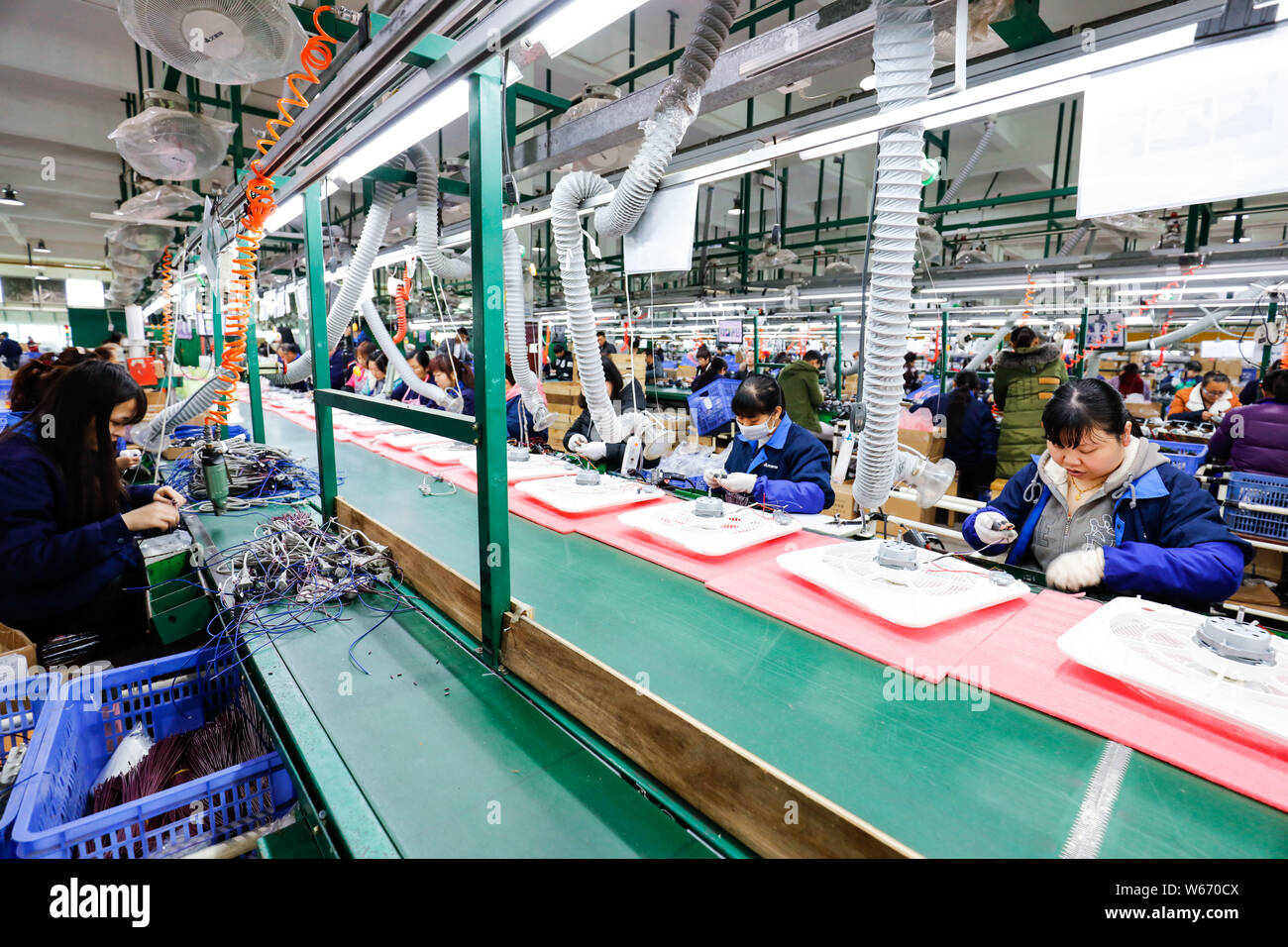 --FILE--Chinese workers manufacture electric fans on the assembly line ...