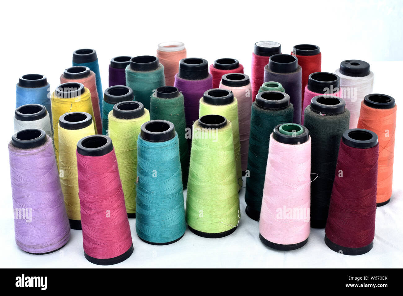 Colorful sewing thread reels on white background Stock Photo - Alamy