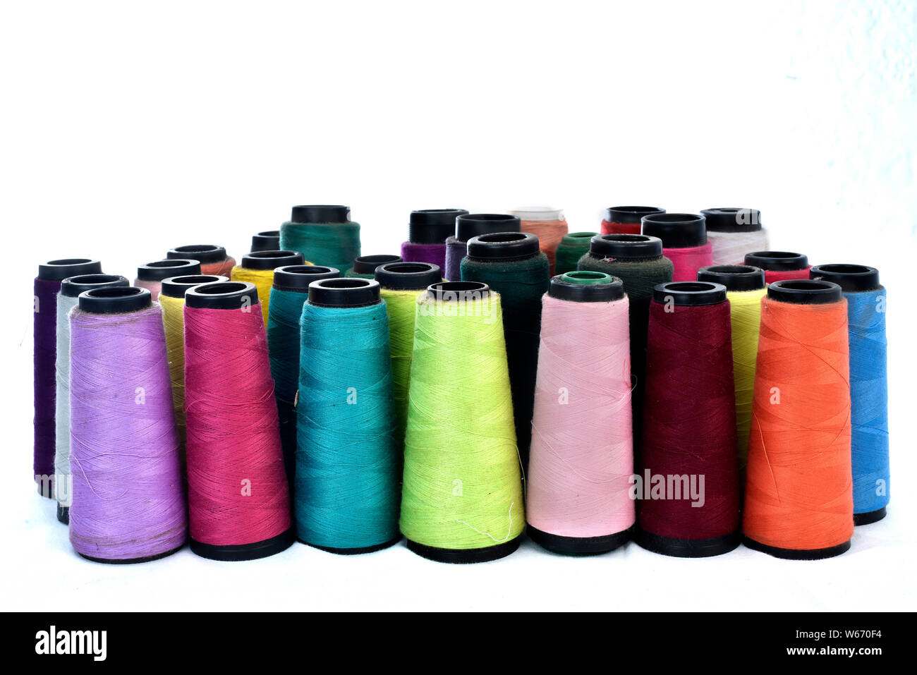 Colorful sewing thread reels on white background Stock Photo - Alamy