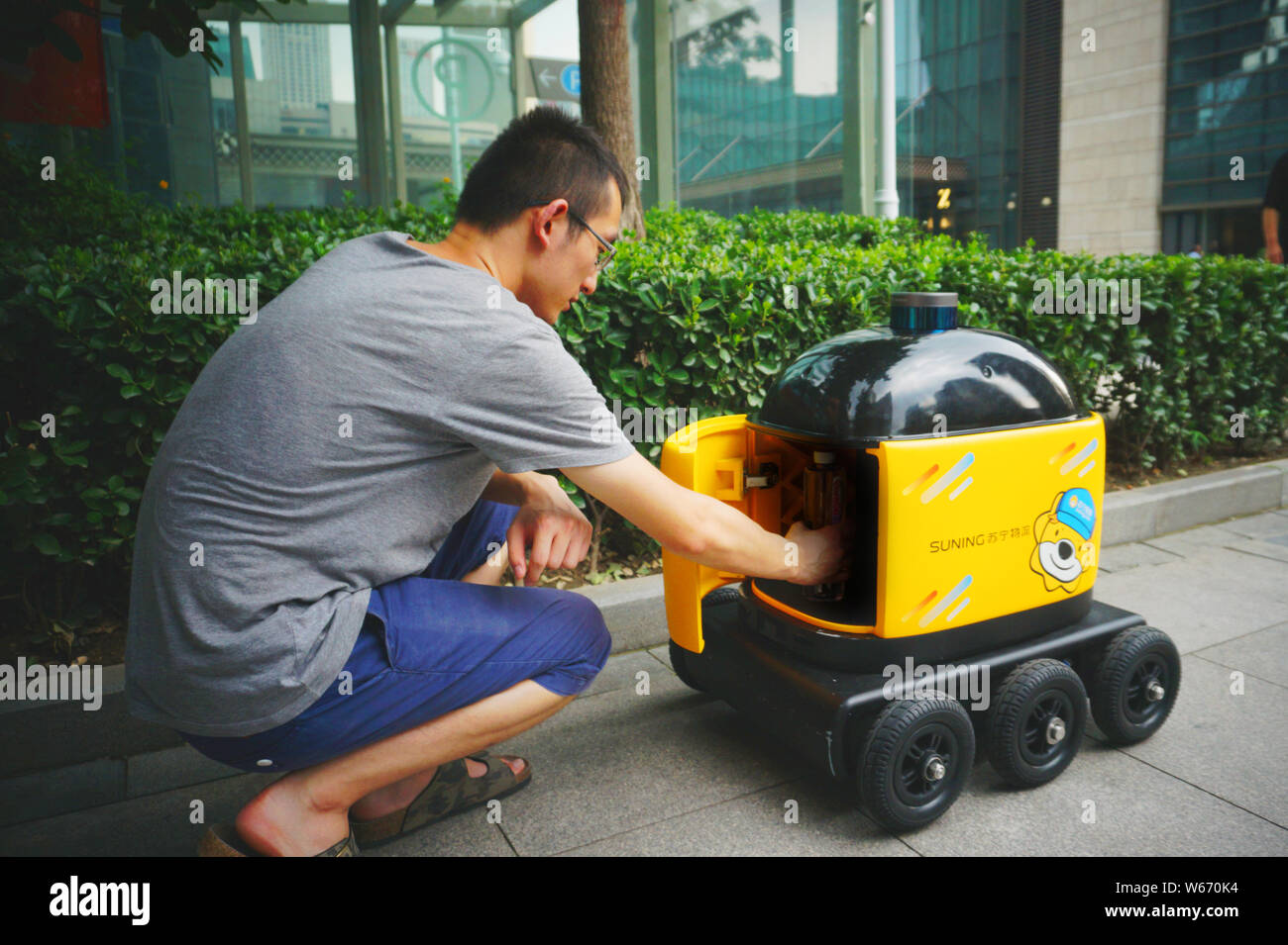 A customer takes a bottle of water from Wolongyihao, the first ...