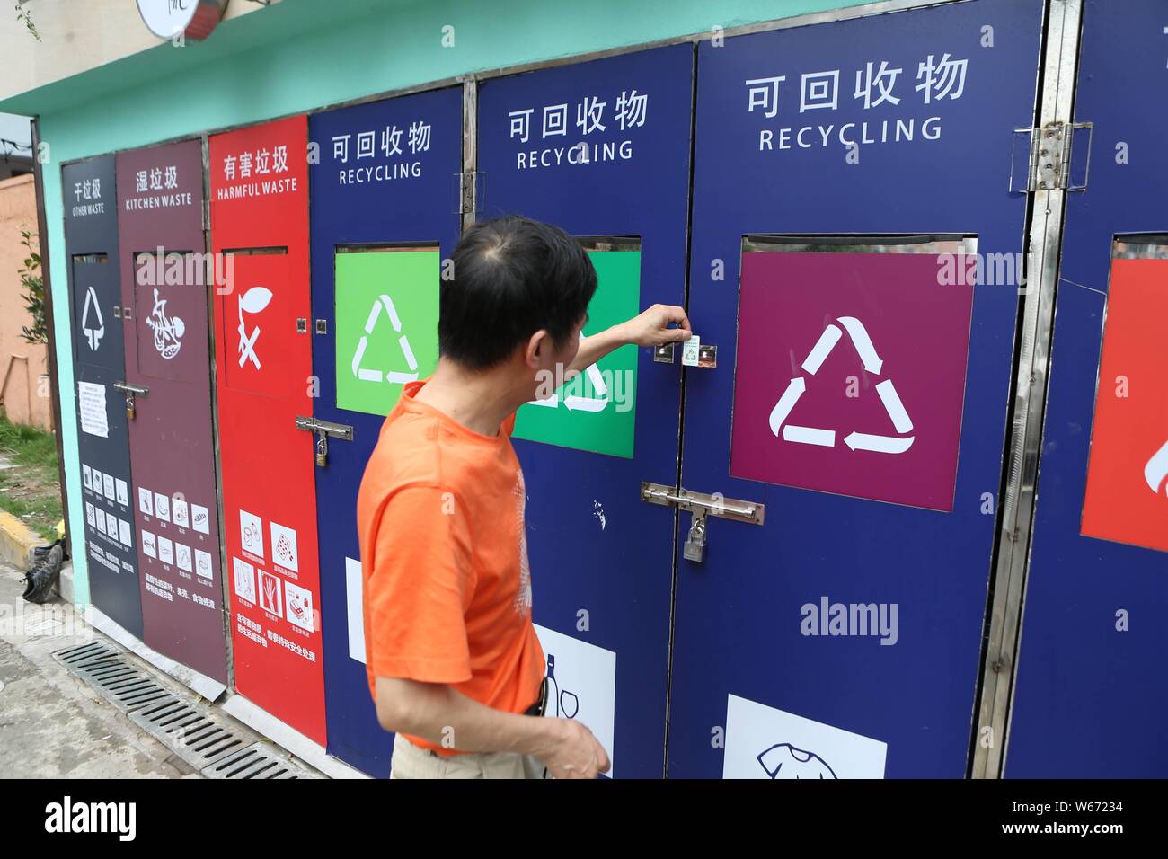 A local resident opens a smart bin deployed to meet the new garbage ...