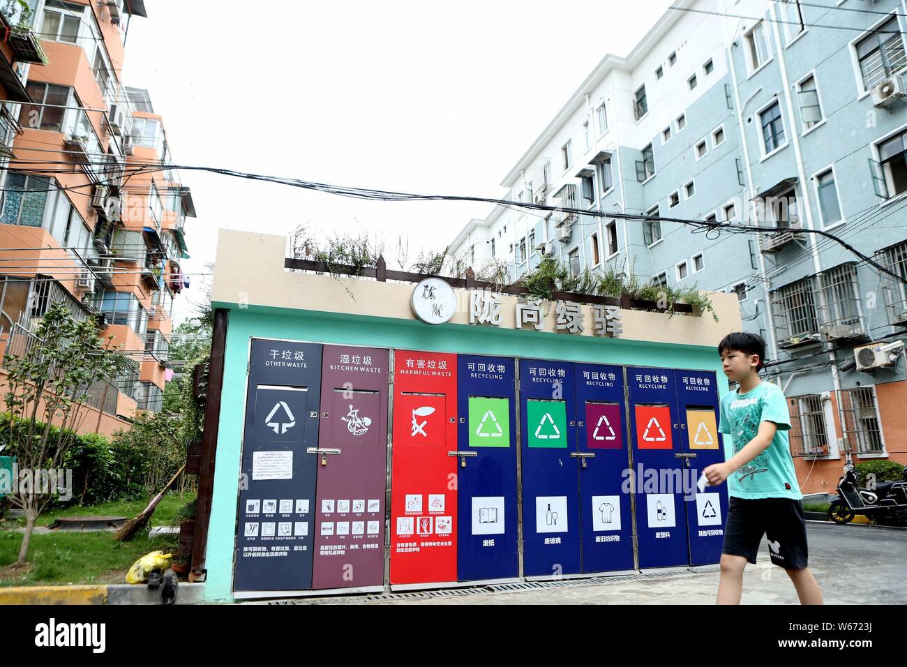 A local resident waks past a smart bin deployed to meet the new garbage ...