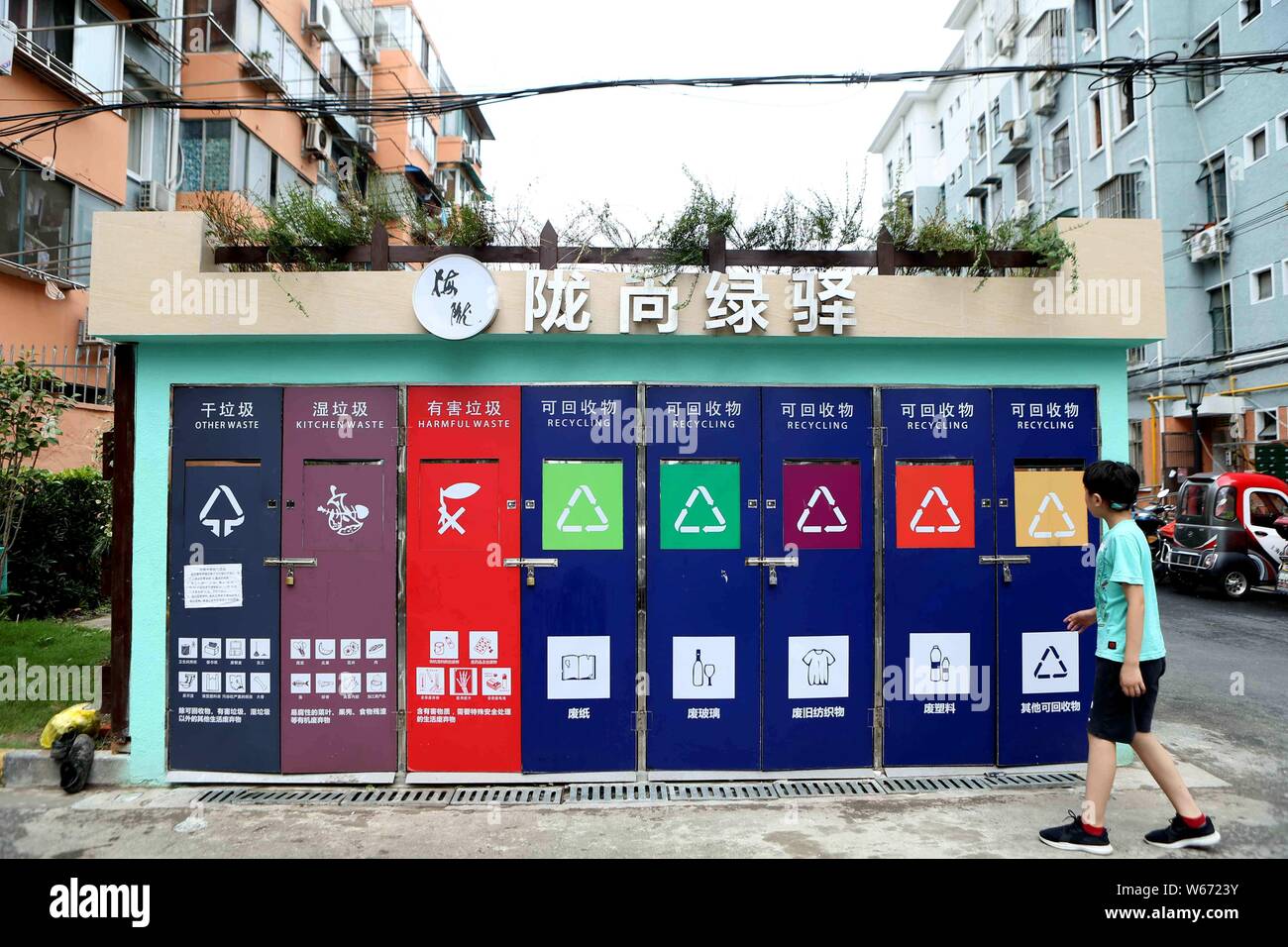 A local resident walks past a smart bin deployed to meet the new ...