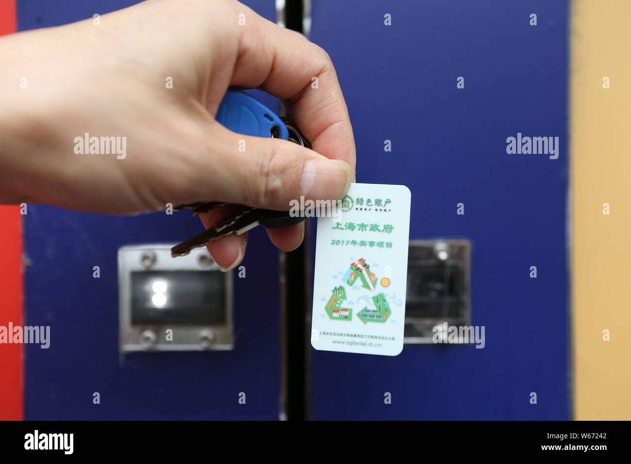 A local resident opens a smart bin deployed to meet the new garbage ...