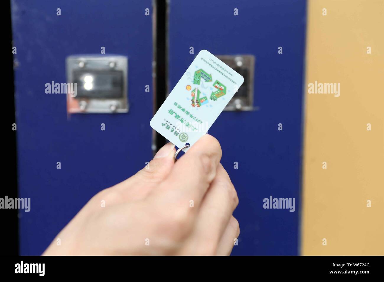 A local resident opens a smart bin deployed to meet the new garbage ...