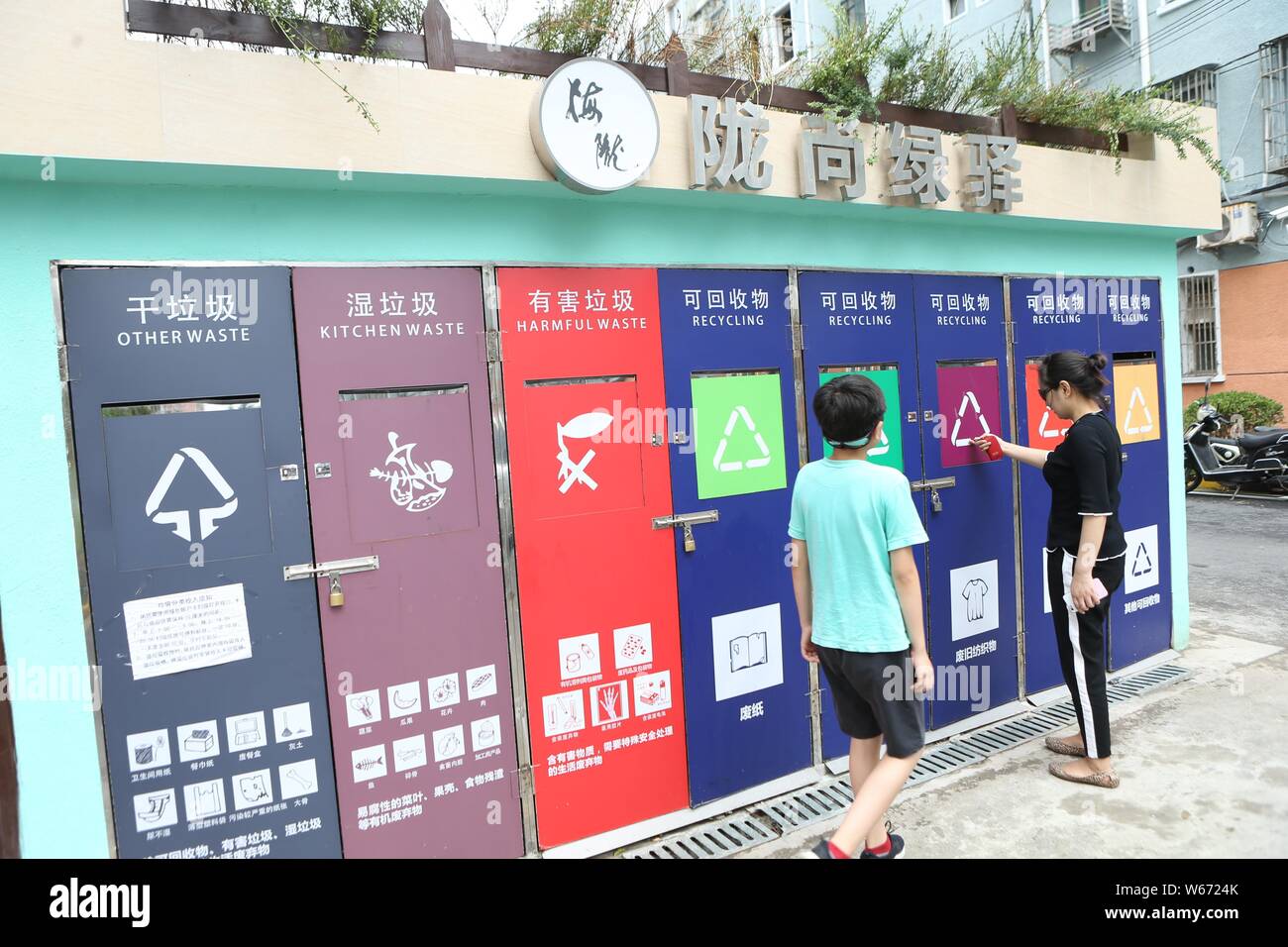 A local resident walks past a smart bin deployed to meet the new ...
