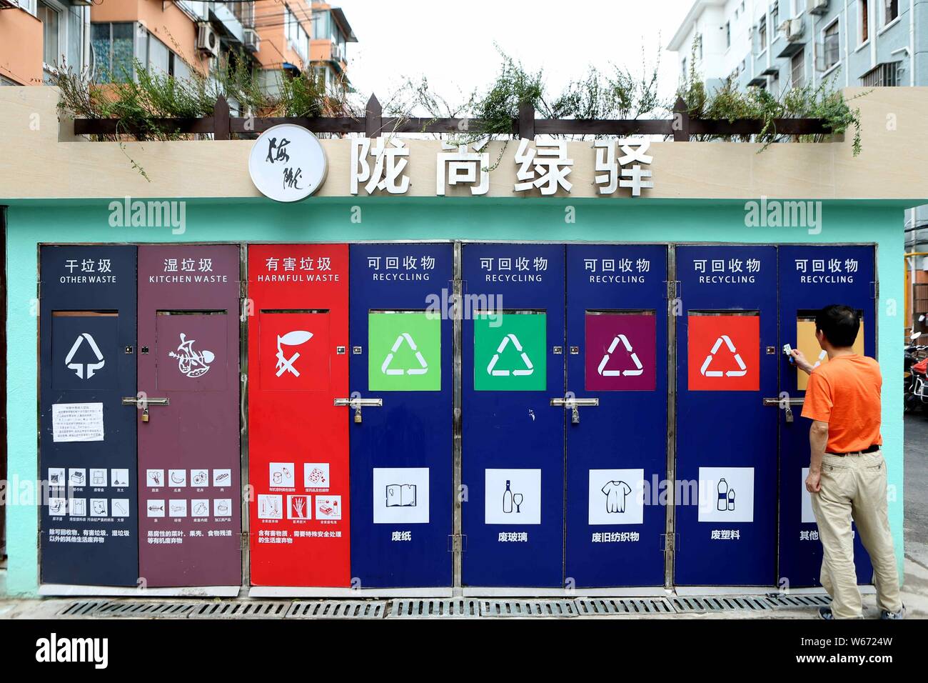 A local resident opens a smart bin deployed to meet the new garbage ...