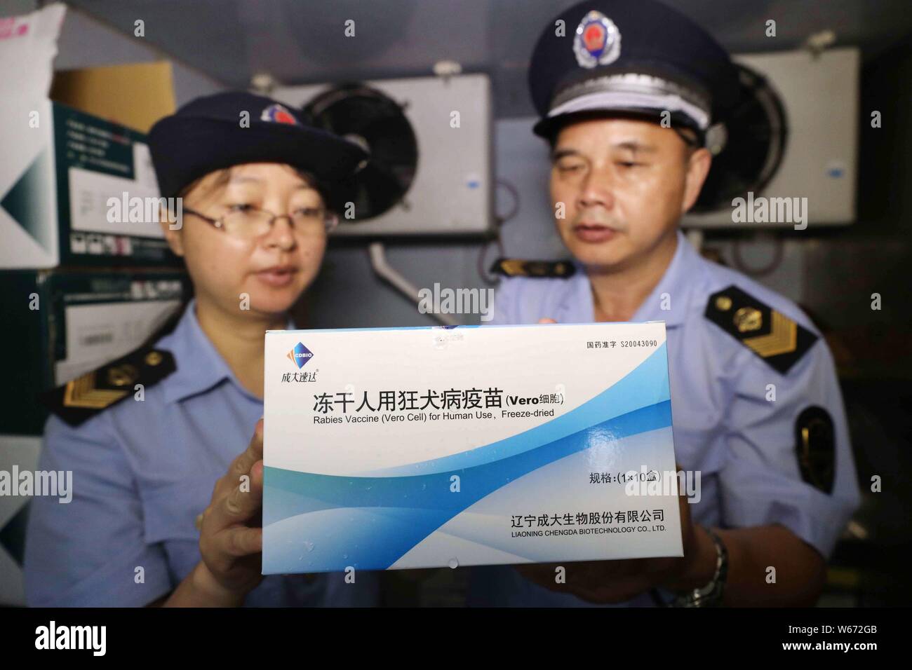 Chinese law enforcement officers examine rabies vaccines produced by ...