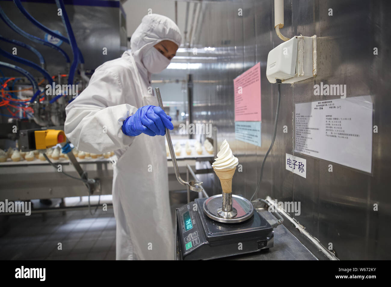 A worker produces Yili torch ice creams on the assembly line at a ...