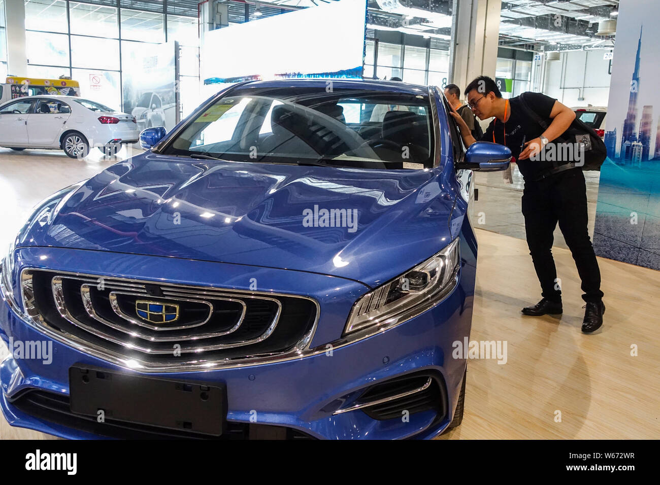 --FILE--A visitor looks at an electric vehicle (EV) of Geely GE during ...