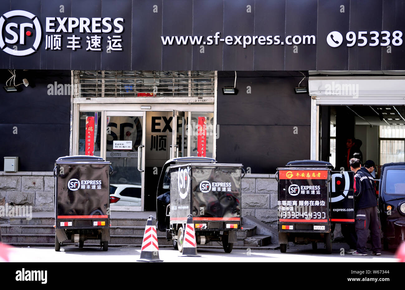 --FILE--Delivery vehicles of SF Express are parked in front of a ...