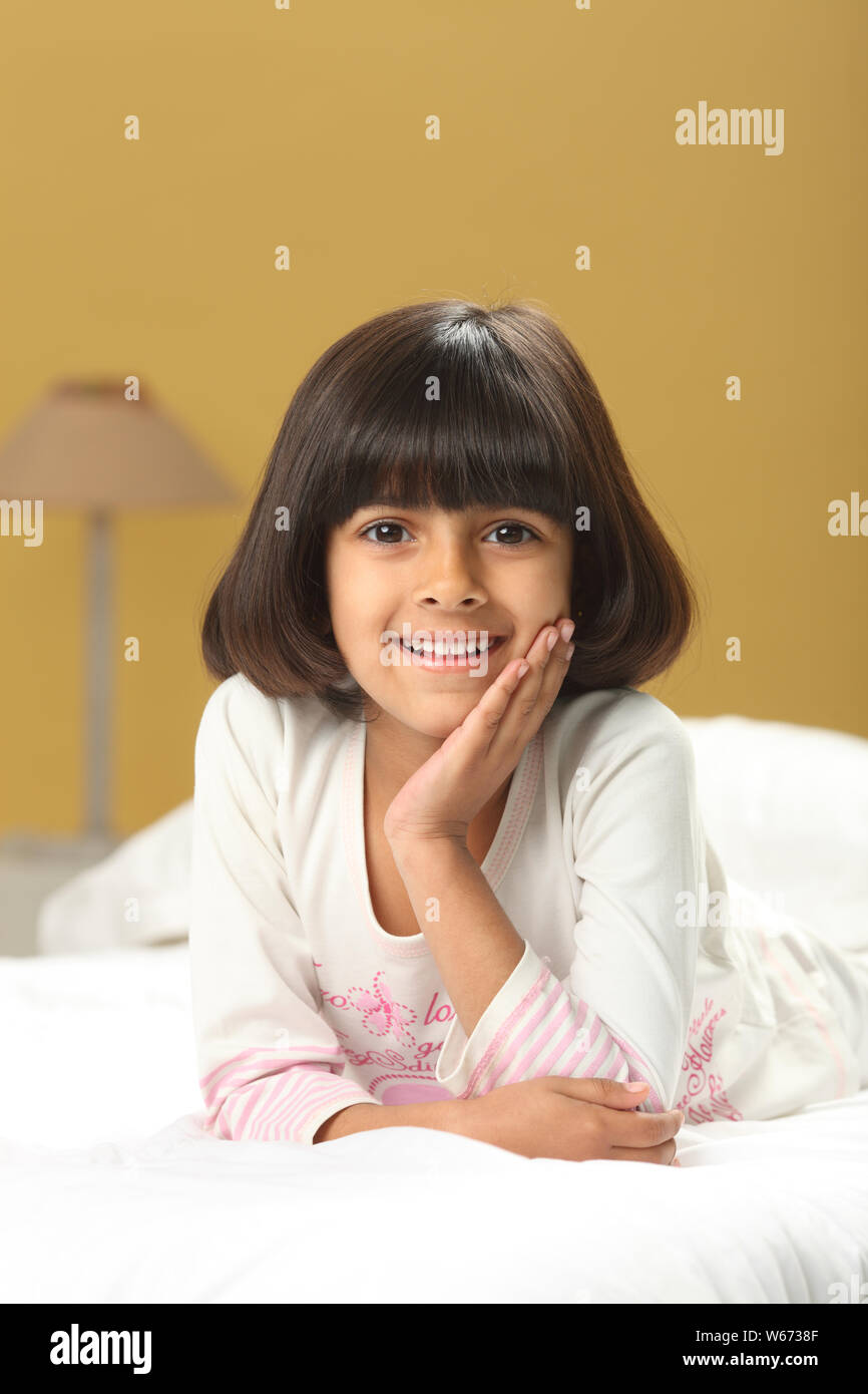 Girl lying on the bed and smiling Stock Photo - Alamy