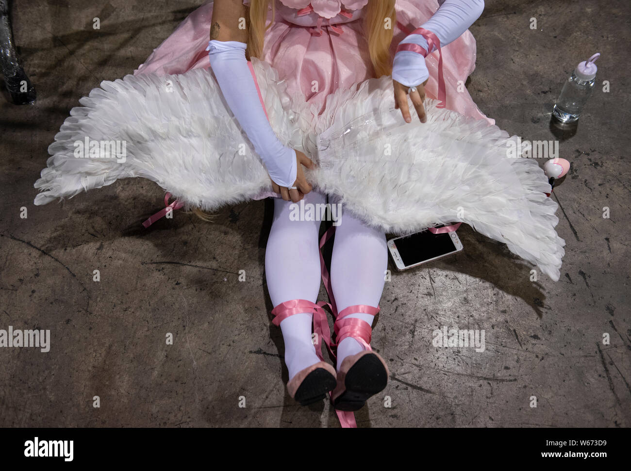 A cosplayer fixes her costume during the Ani-com and E-Sports and Music ...