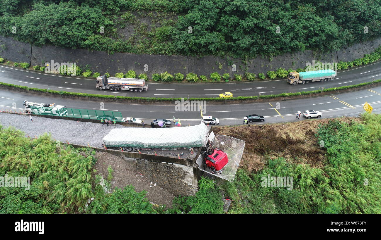 An aerial view of the cargo truck with its cabin dangling off the cliff ...