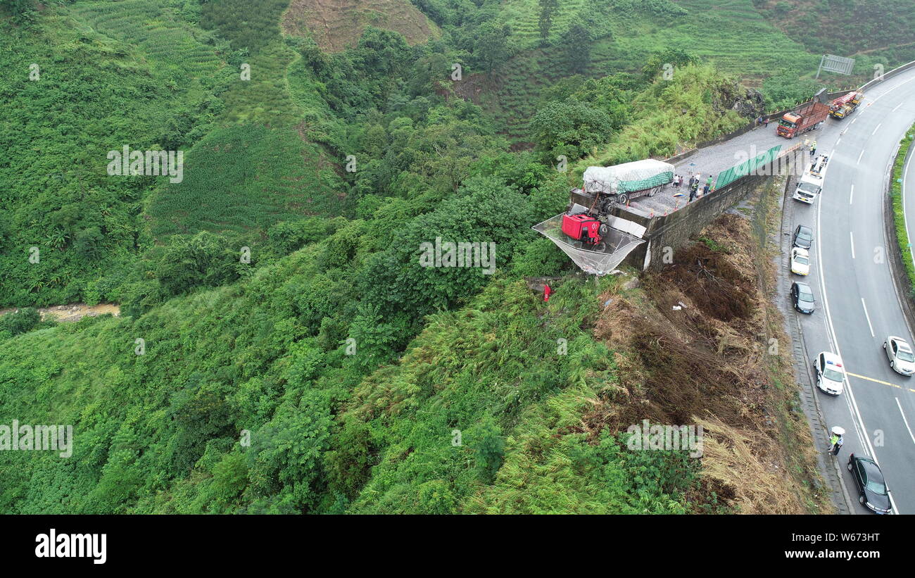 An aerial view of the cargo truck with its cabin dangling off the cliff ...