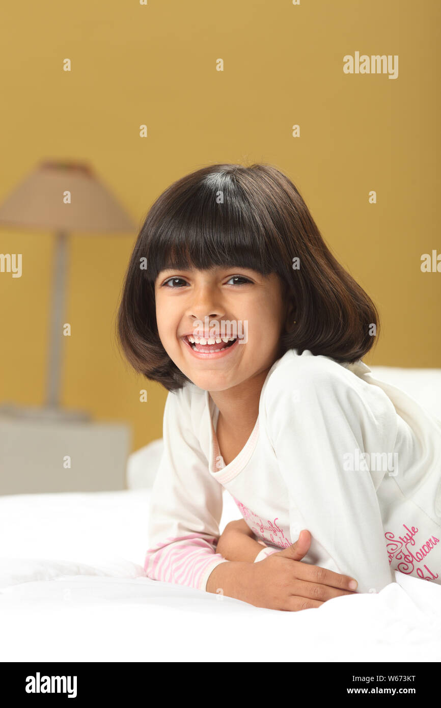 Girl lying on the bed and smiling Stock Photo - Alamy