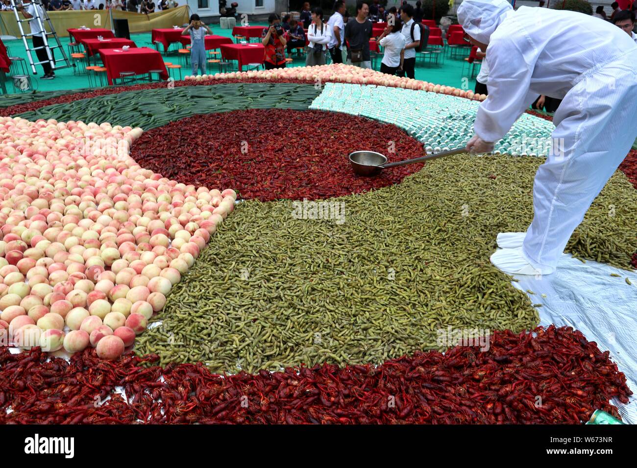 A chef prepares huge assorted dishes during a crayfish banquet at the Laojun Mountain scenic ...