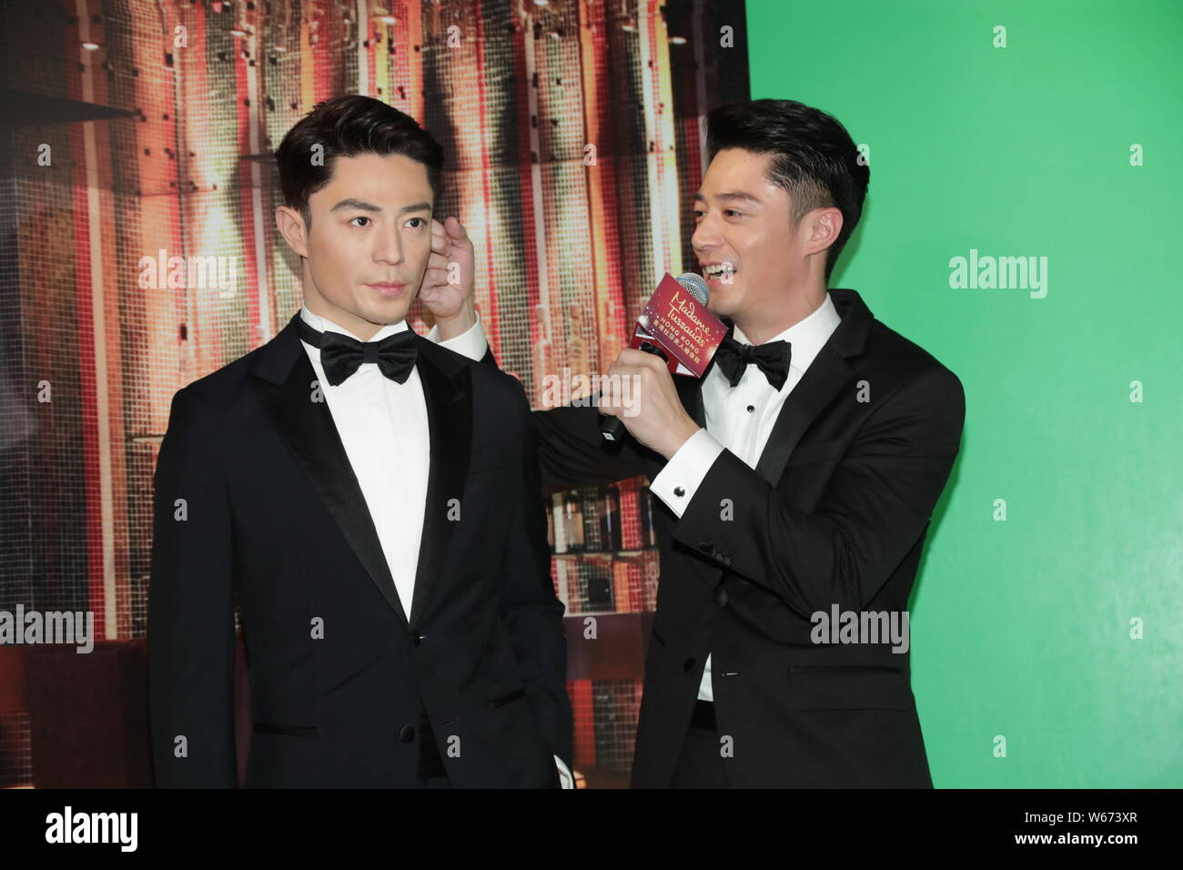 Taiwanese actor Wallace Huo, right, speaks next to a wax figure of him ...