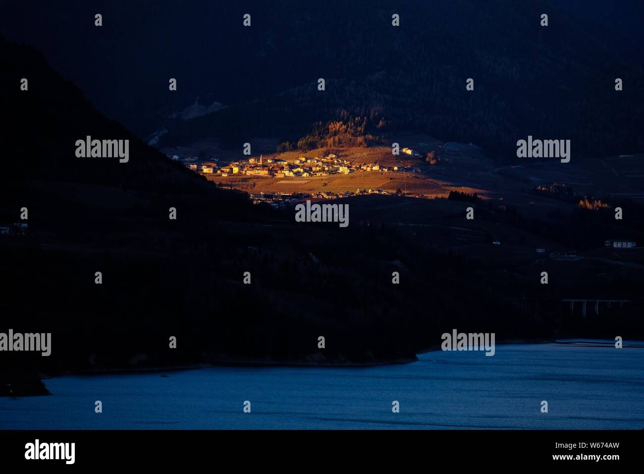 Long-range shot trees on the shore near the water and building in the ...