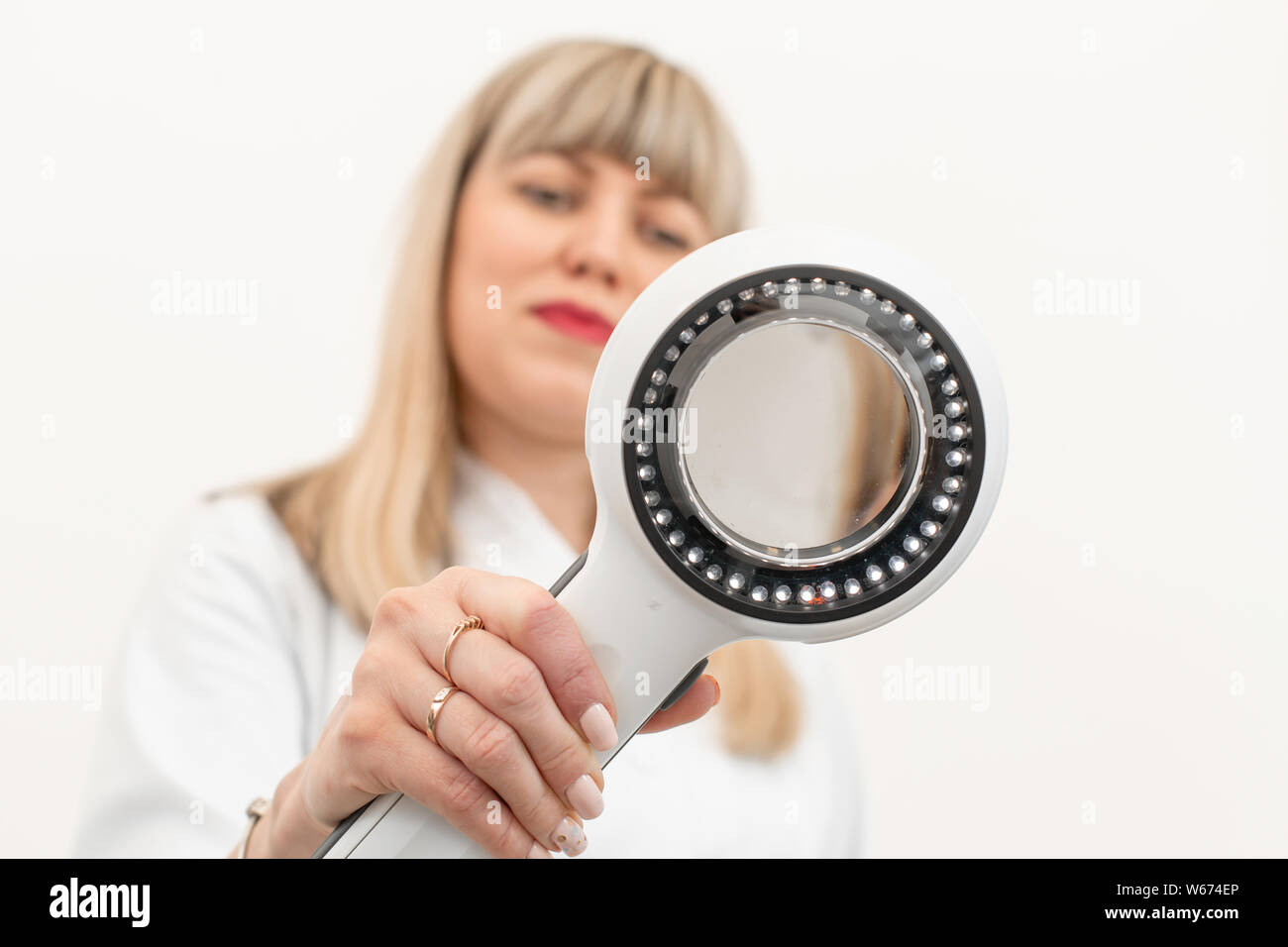 The doctor trichologist dermatologist examines the camera through the ...