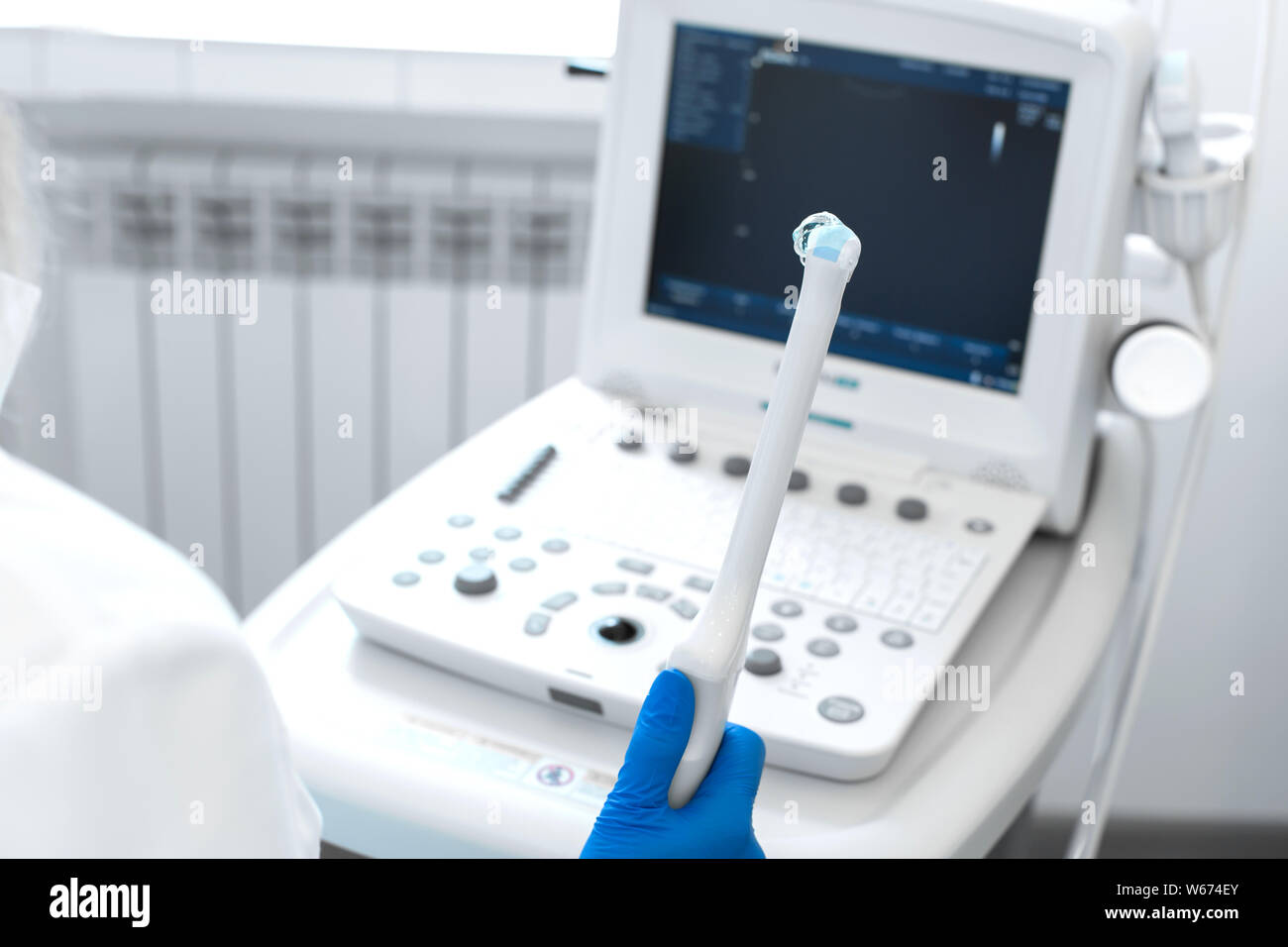 the gynecologist holds the sensor of the ultrasound device with the gel ...