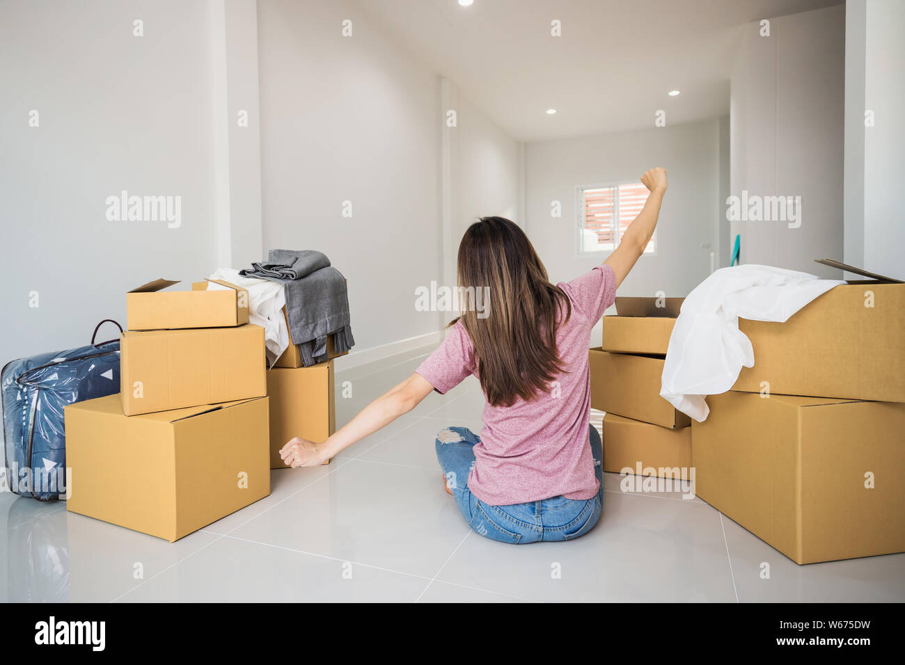 Young asian woman moving into new home Stock Photo - Alamy