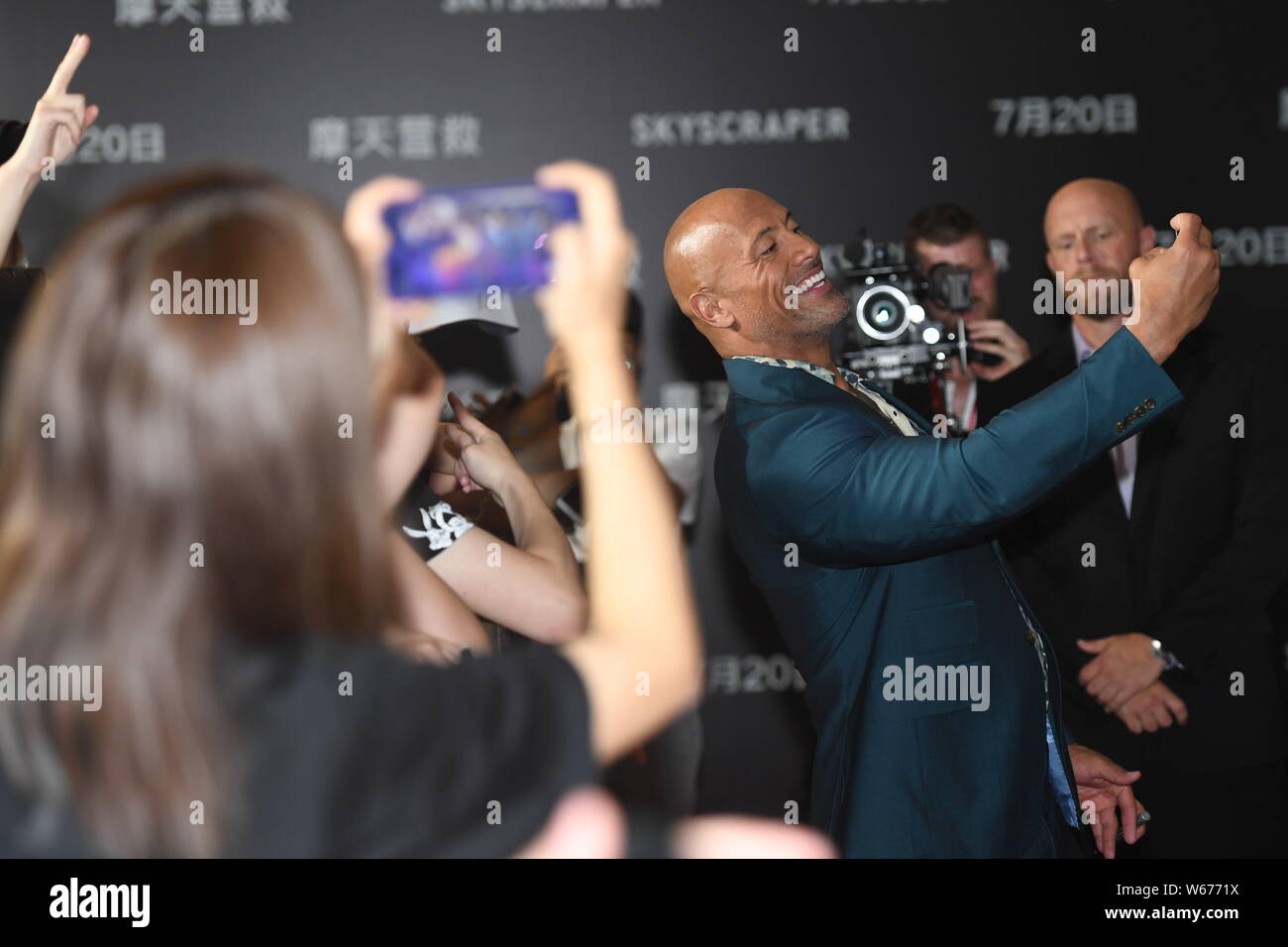 American actor Dwayne Johnson takes a selfie with fans as he arrives on ...