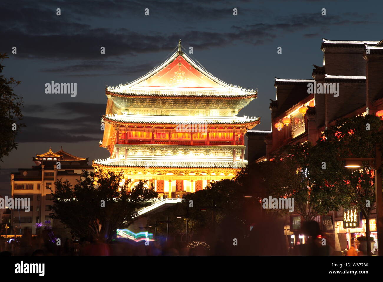 Tourists visit the Bell Tower after a rainfall at sunset in Xi'an city ...
