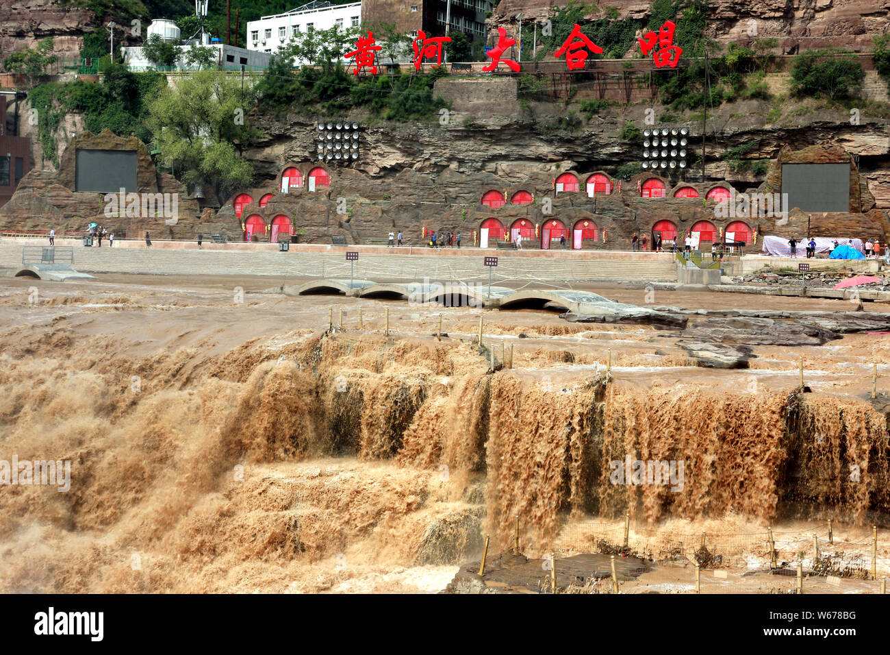 Tourists visit the roaring Hukou Waterfall on the Yellow River after ...