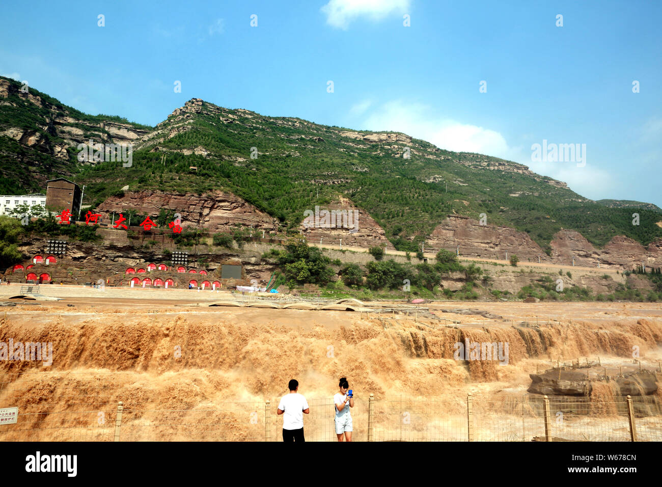 Tourists visit the roaring Hukou Waterfall on the Yellow River after ...